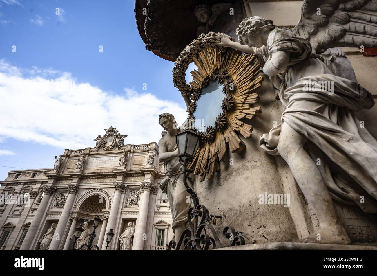 Baroque sculptures in front of the Trevi Fountain with blue sky and ...