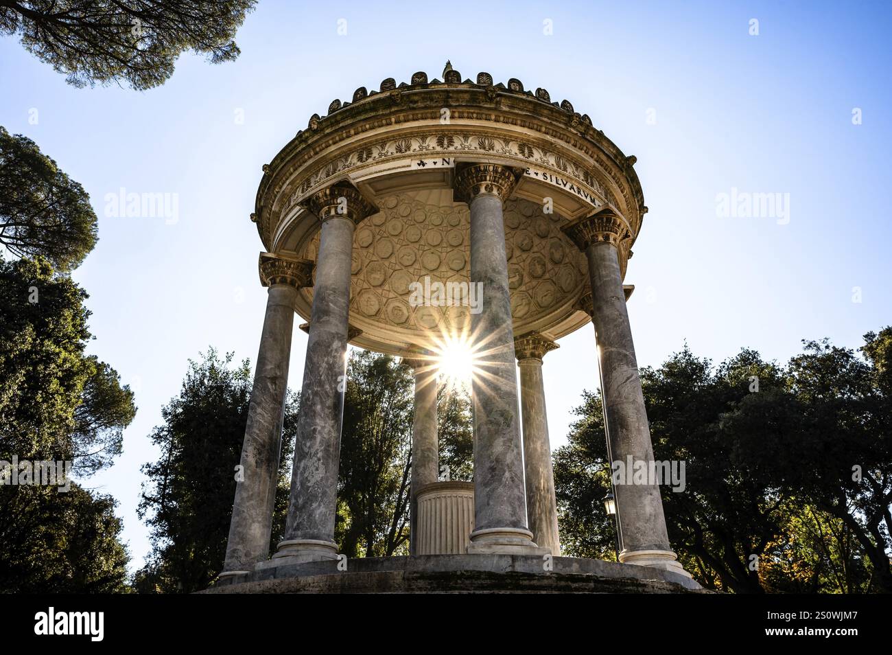 Classic pavilion with columns and sunlight in a wooded area, Rome Stock ...