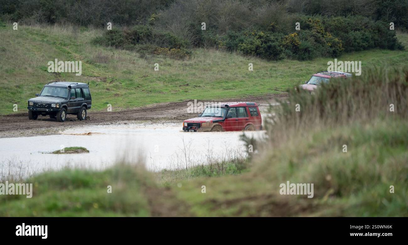 a group of 4x4 land rover discovery series II off-roading and wading ...