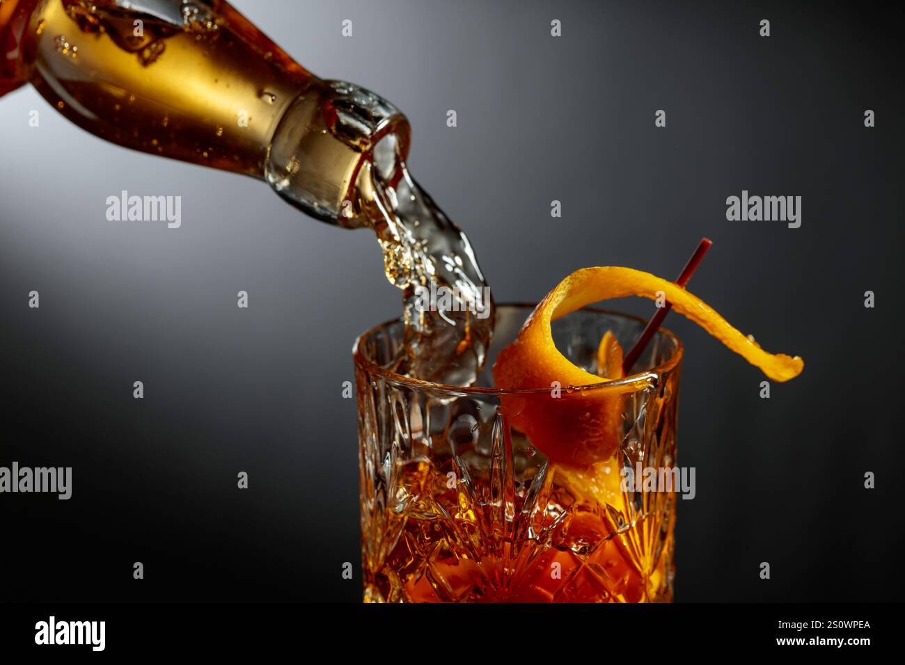 Whiskey or bourbon pouring into a crystal glass. Old-fashioned cocktail ...