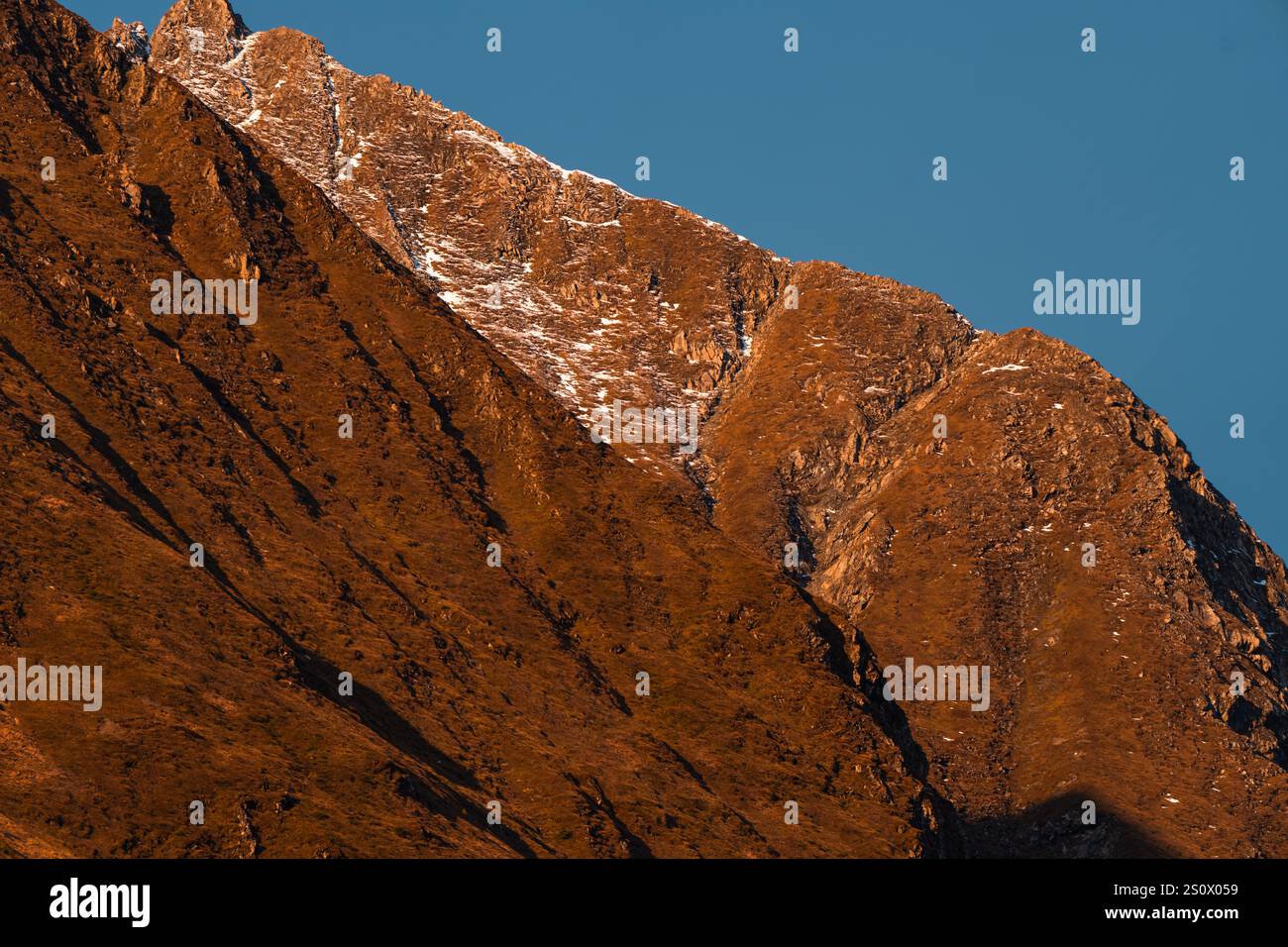 mountain summit and ridge. dramatic steep red stone cliff in sun light ...