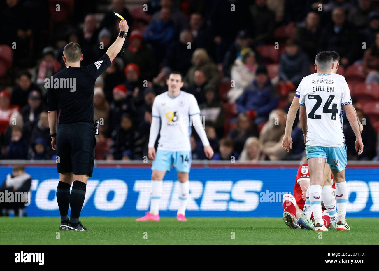 Referee Josh Smith shows a yellow card to Burnley's Josh Cullen (right ...