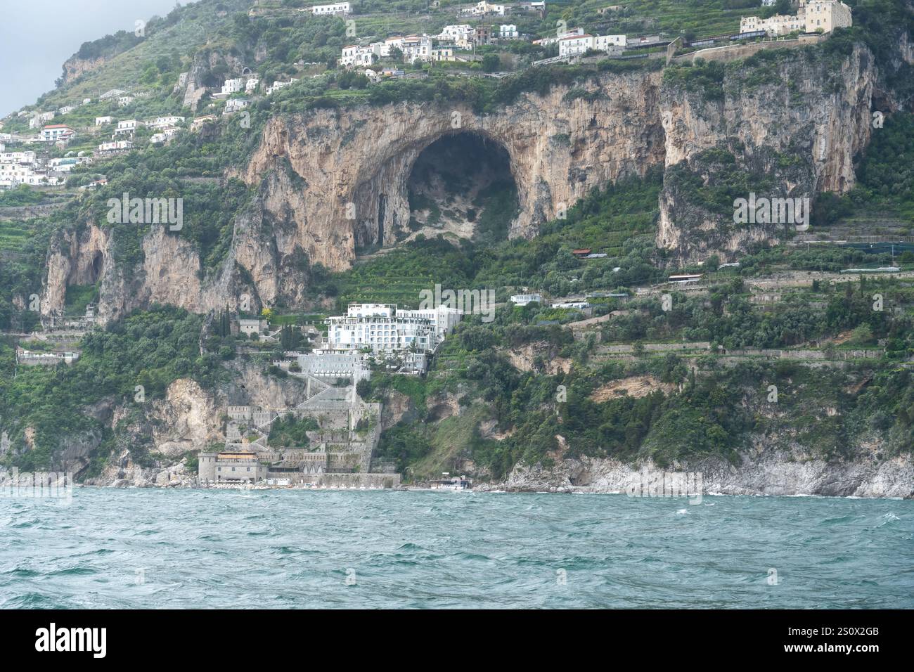 a 50m high rock grotto above a large white coastline building. Amalfi ...