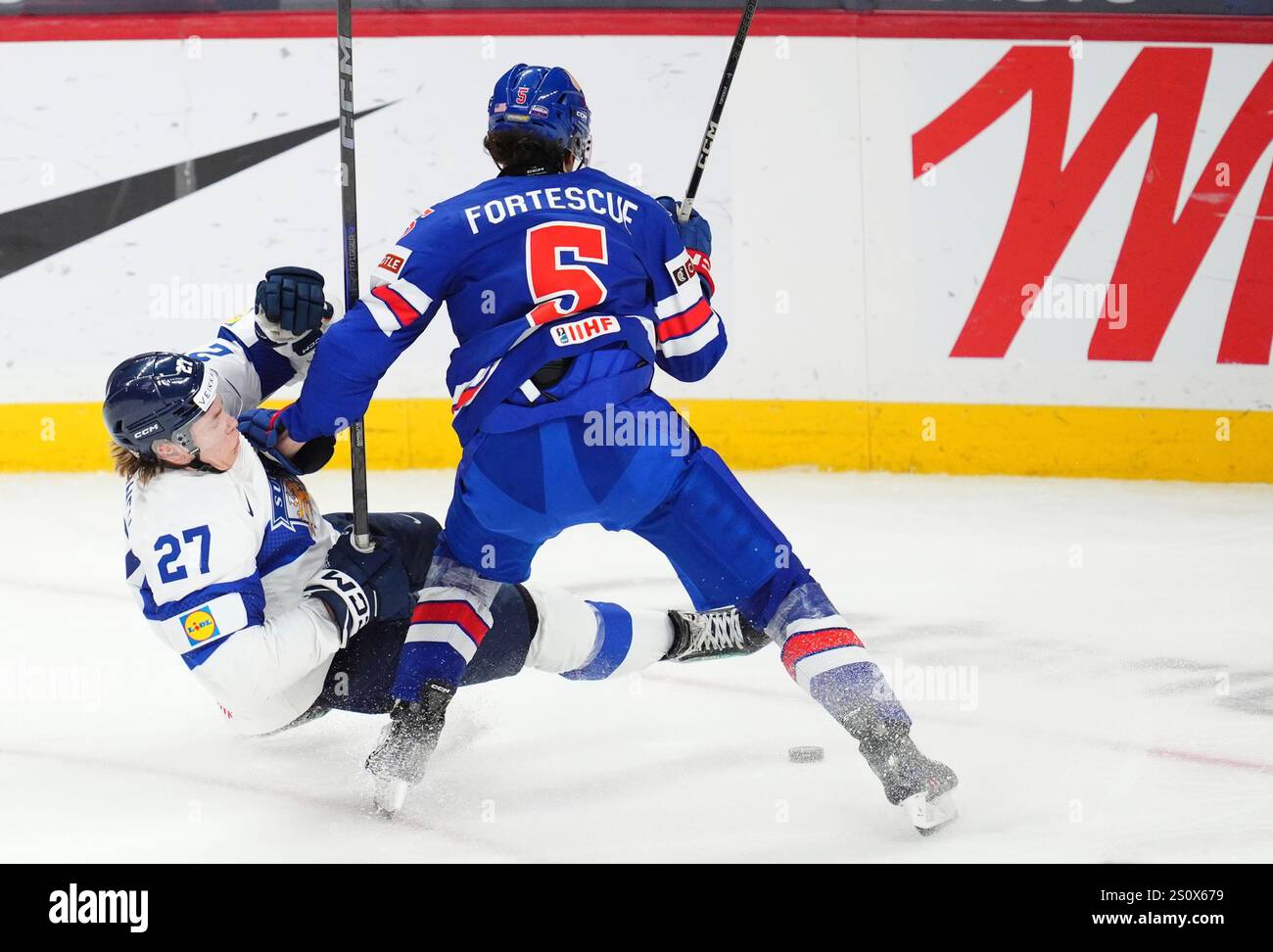 United States defenseman Drew Fortescue (5) pushes Finland forward ...
