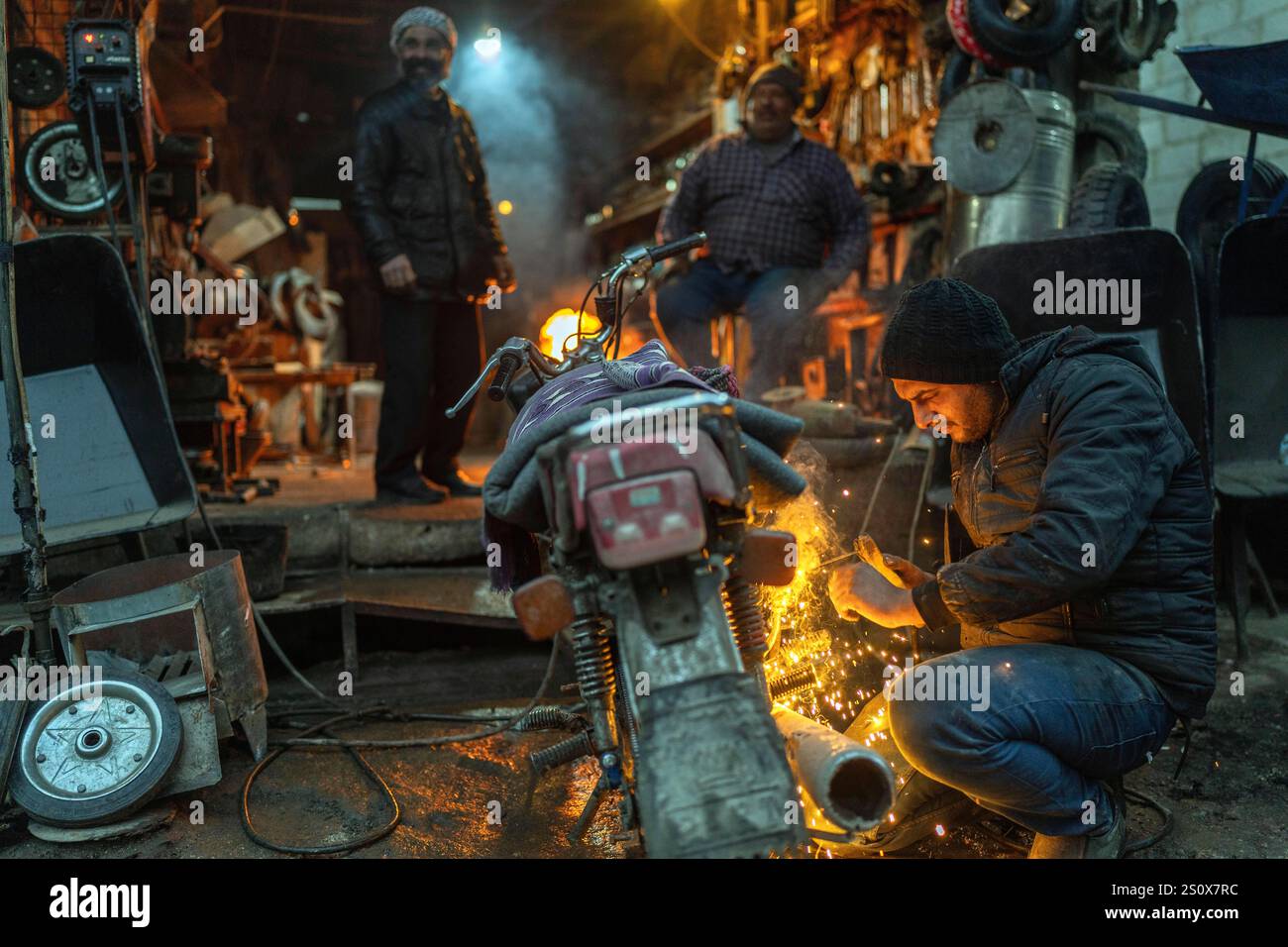 A technician fixes a motorbike at a tyre shop in Douma, on the ...