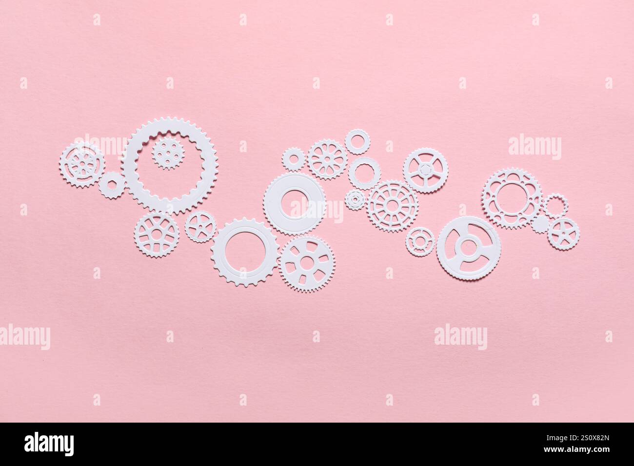 White paper gears on pink background Stock Photo - Alamy