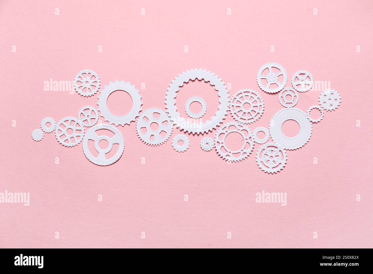 White paper gears on pink background Stock Photo - Alamy