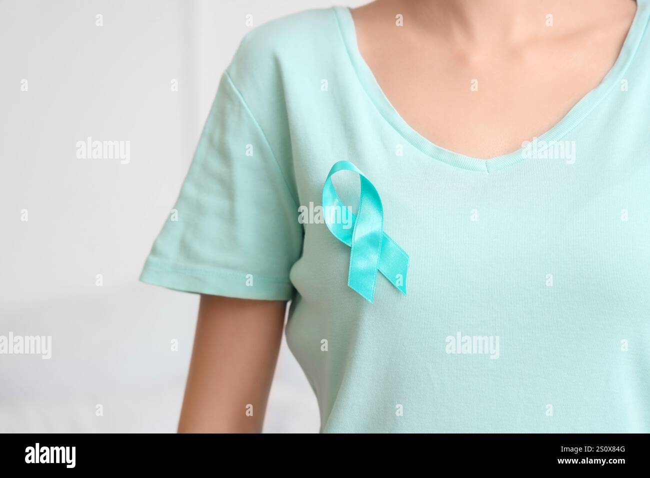 Young woman with turquoise ribbon in bedroom, closeup. Cervical Health ...