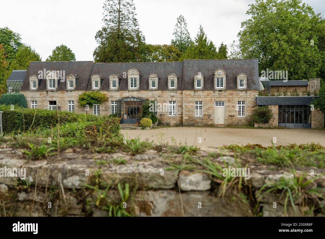 converted accommodation stables in beige stone at Chateau de Kergrist, France. Medieval estate ...