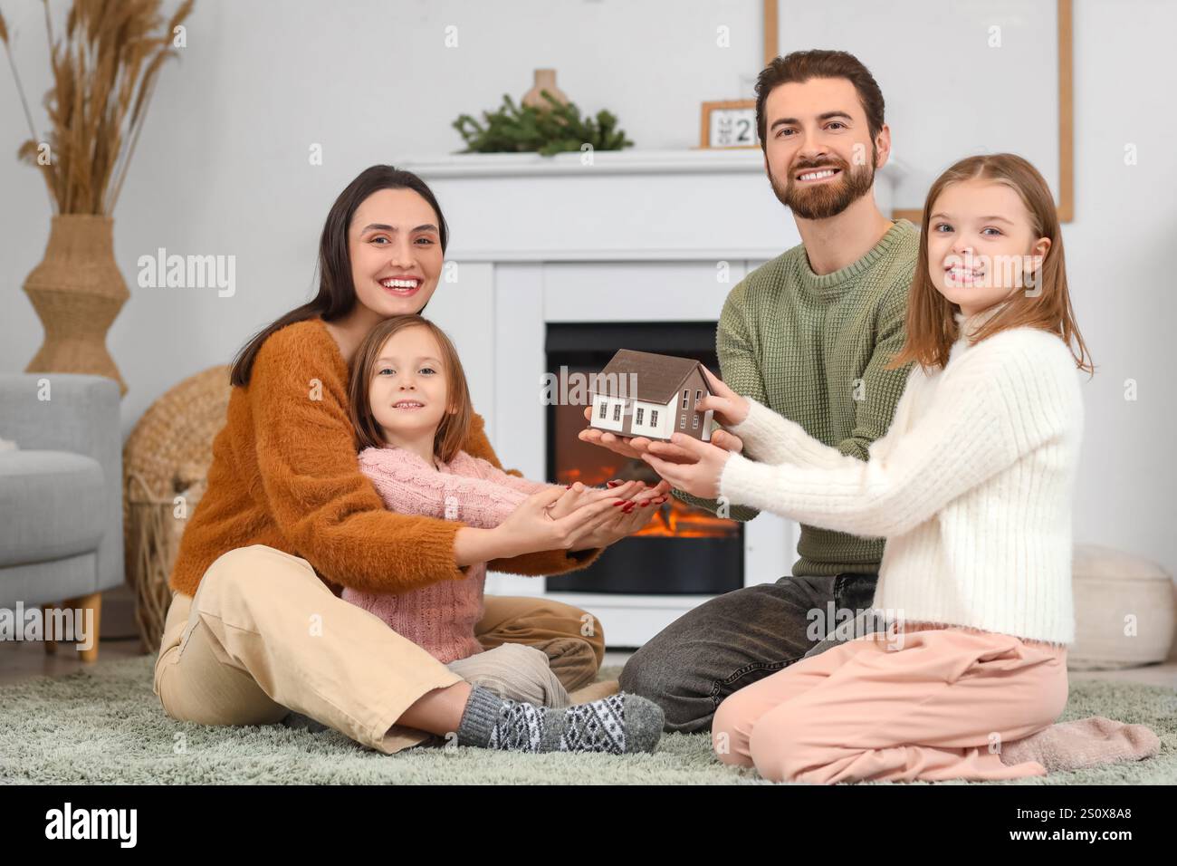 Young family with model of house at home Stock Photo - Alamy