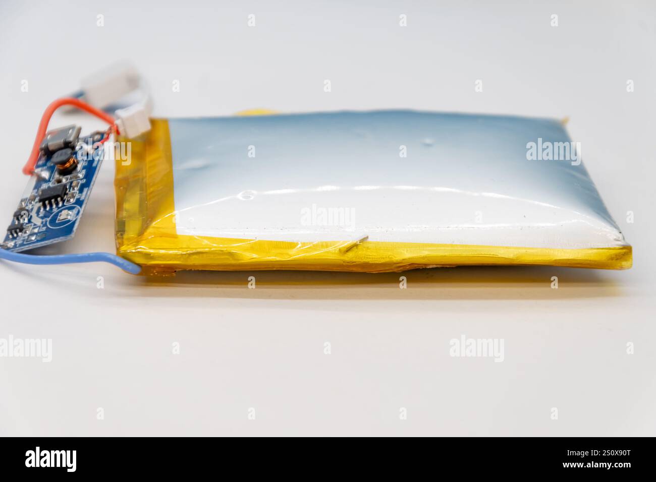 Bloated lithium-ion battery with USB connector on white background ...