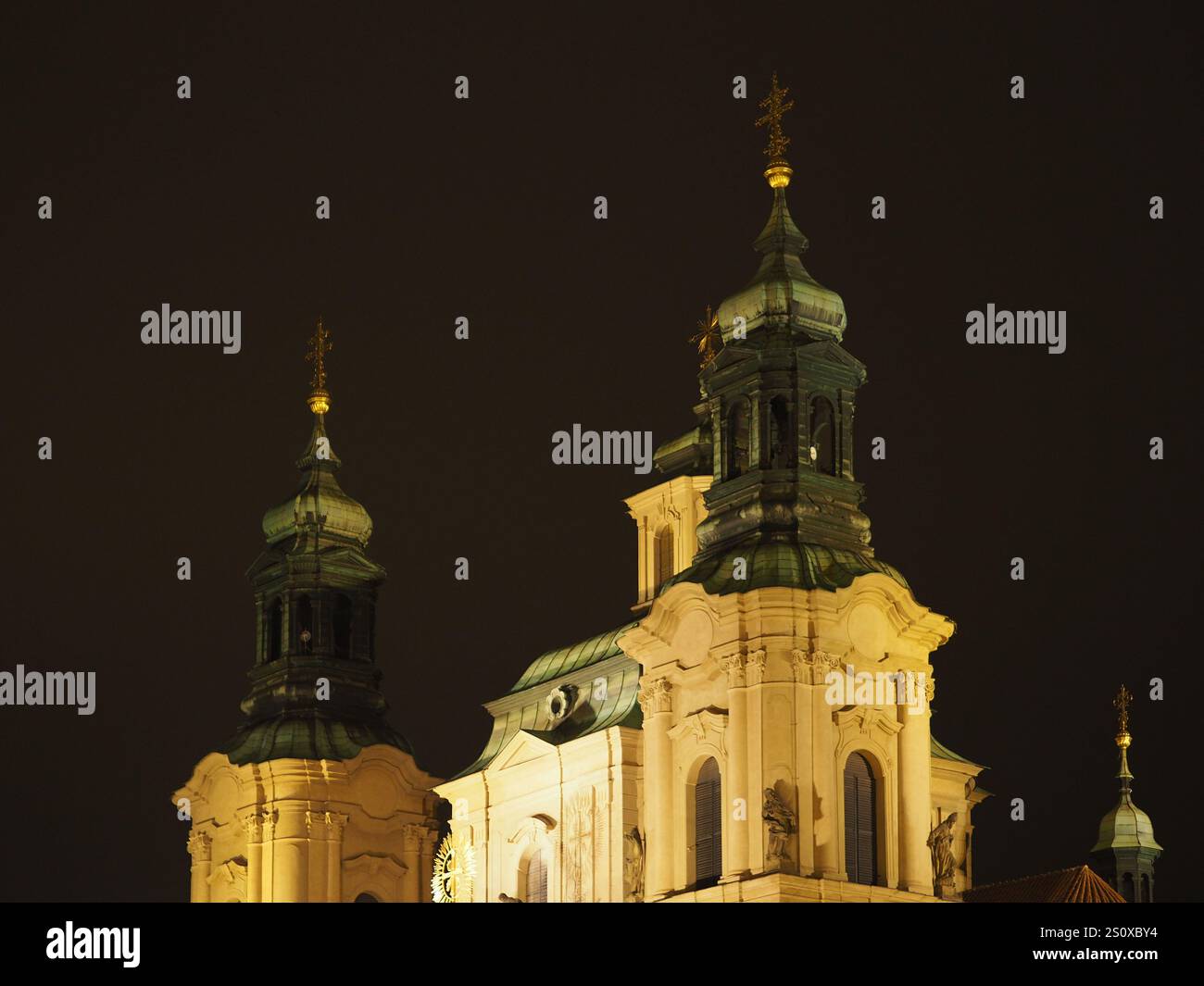 Ornate church towers with golden spires and domes lit up against dark ...