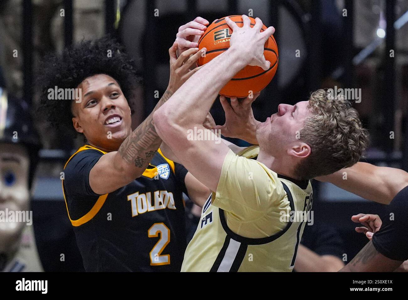 Toledo guard Bryce Ford (2) and Purdue forward Caleb Furst (1) fight ...