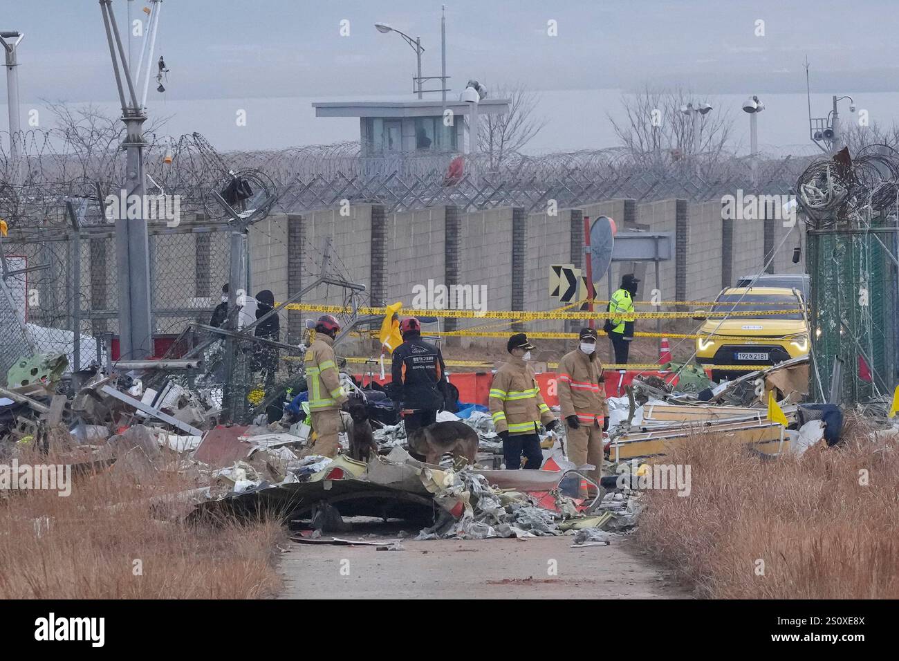 Rescue team members work near the site of a plane fire outside of Muan ...