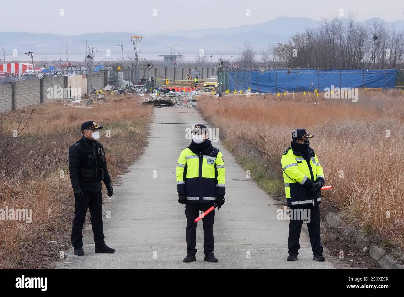 Police officers stand guard near the site of a plane fire outside of ...