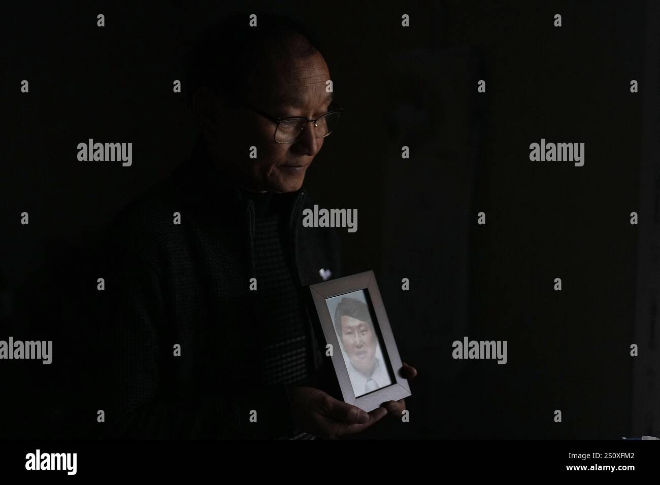 Kim Jeong-sam holds a photo of his brother of missionary Kim Jung Wook ...