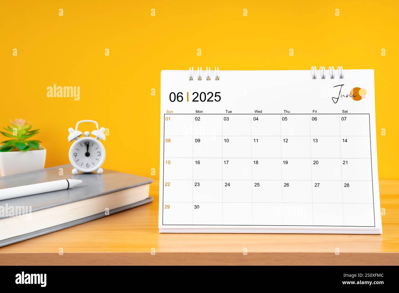 June desk calendar for 2025 year on work table with yellow background ...