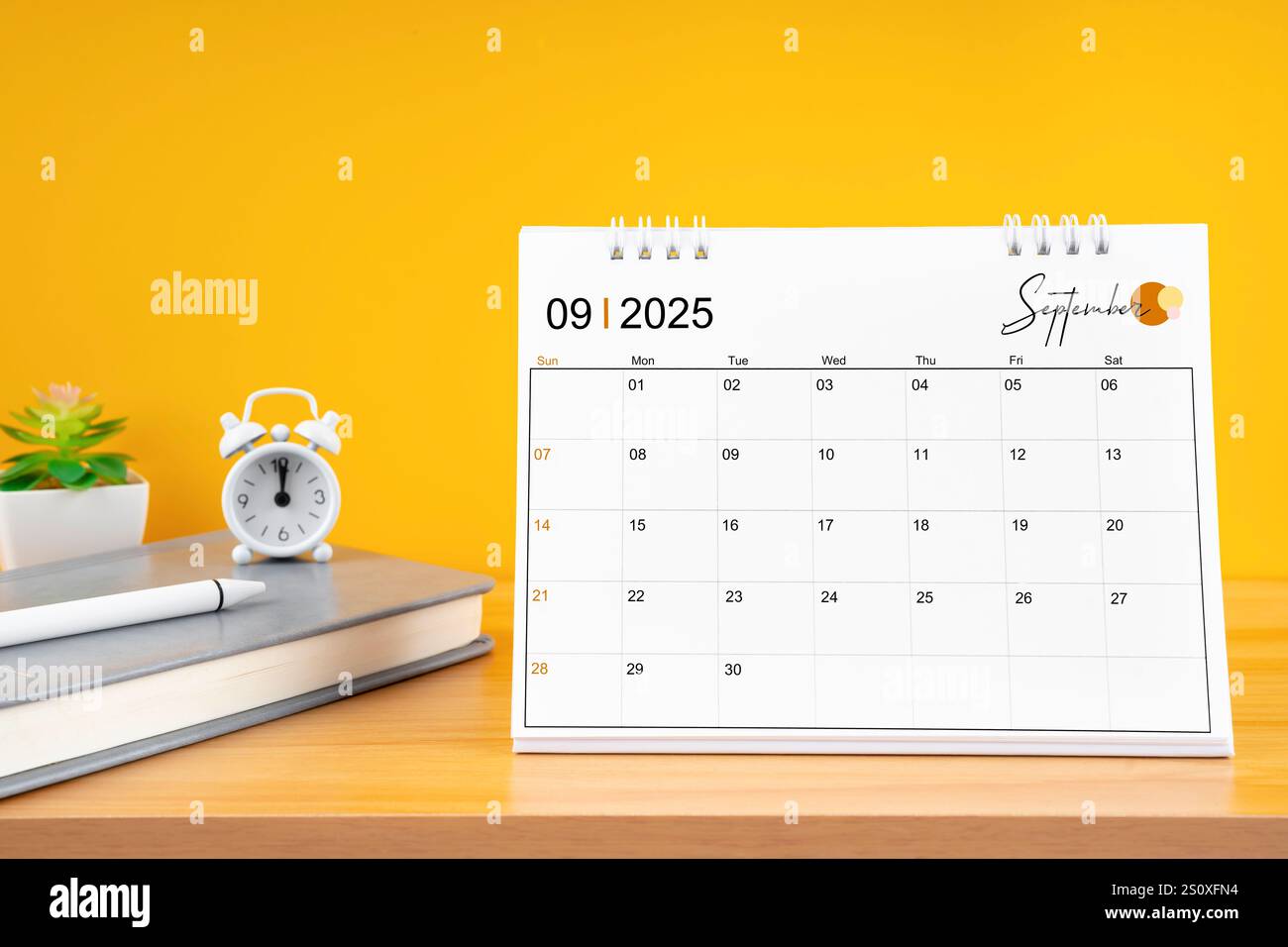 September desk calendar for 2025 year on work table with yellow ...