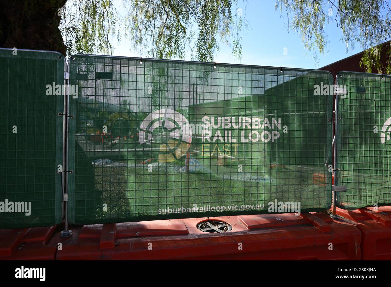 Backlit green Suburban Rail Loop barrier mesh, featuring the transport ...