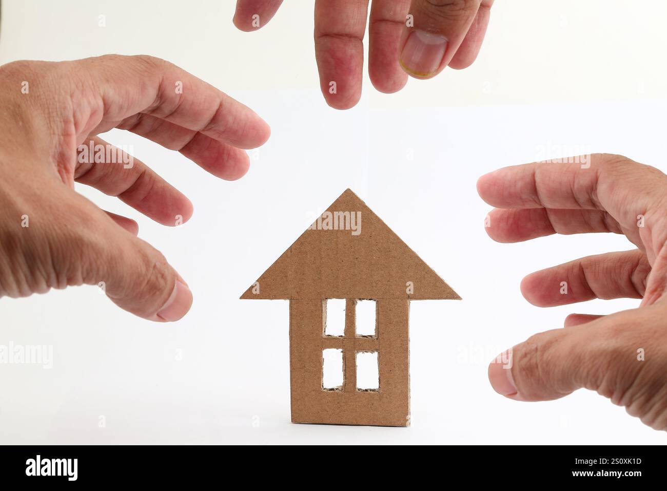 Human hand grabbing a paper house on a white background Stock Photo - Alamy