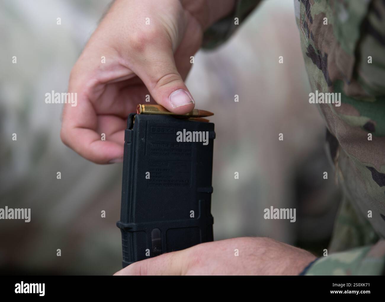 A U.S. Airman loads a 5.56 caliber round into a magazine at the long ...