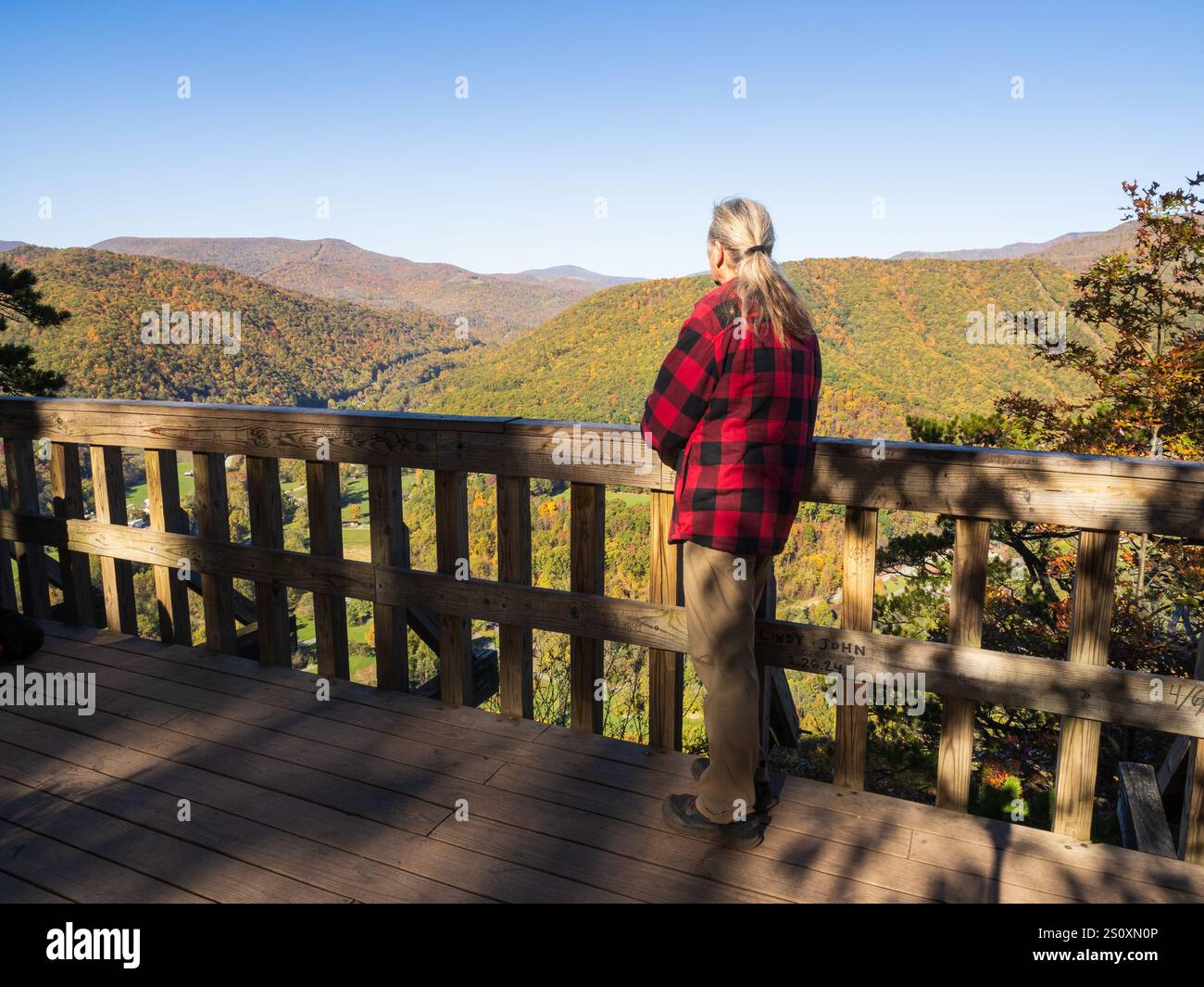 Standing atop Seneca Rocks, a man in a red lumberjack jacket and ...