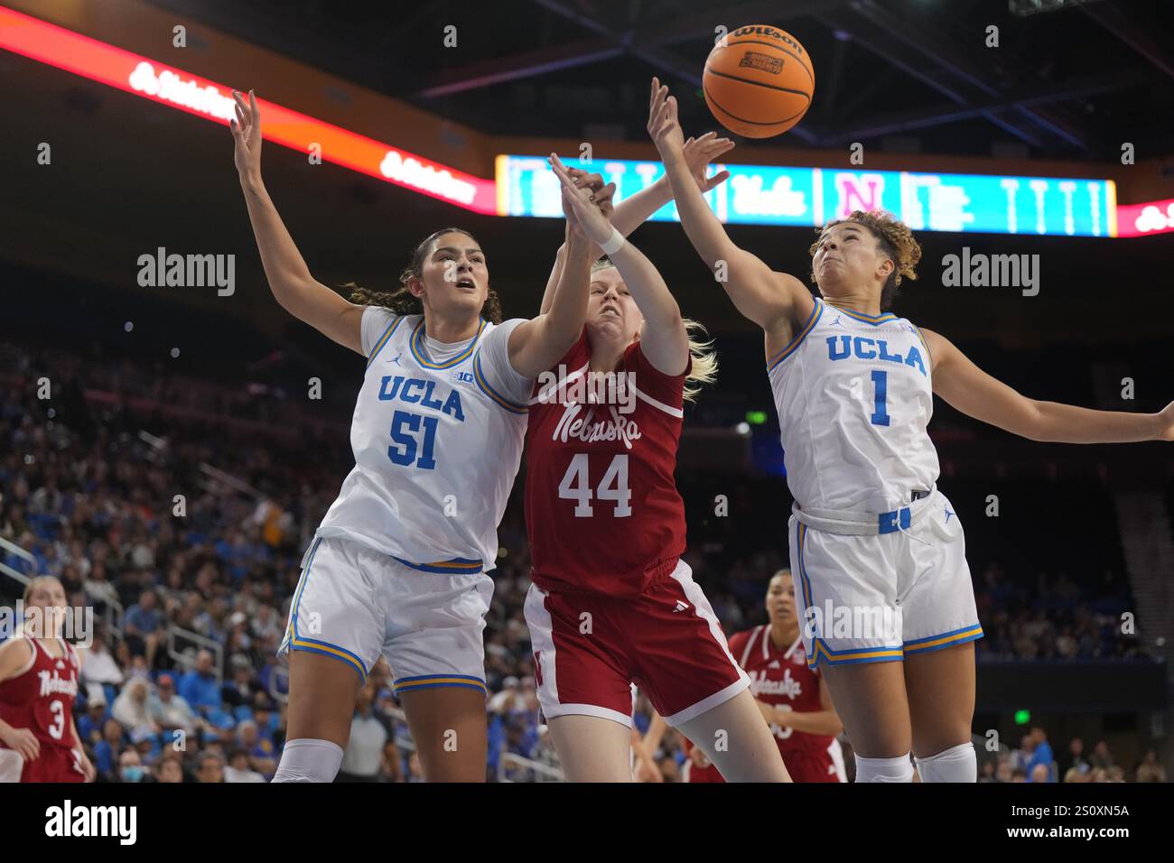 UCLA Bruins center Lauren Betts (51) and guard Kiki Rice (1) battle for the ball with Nebraska ...