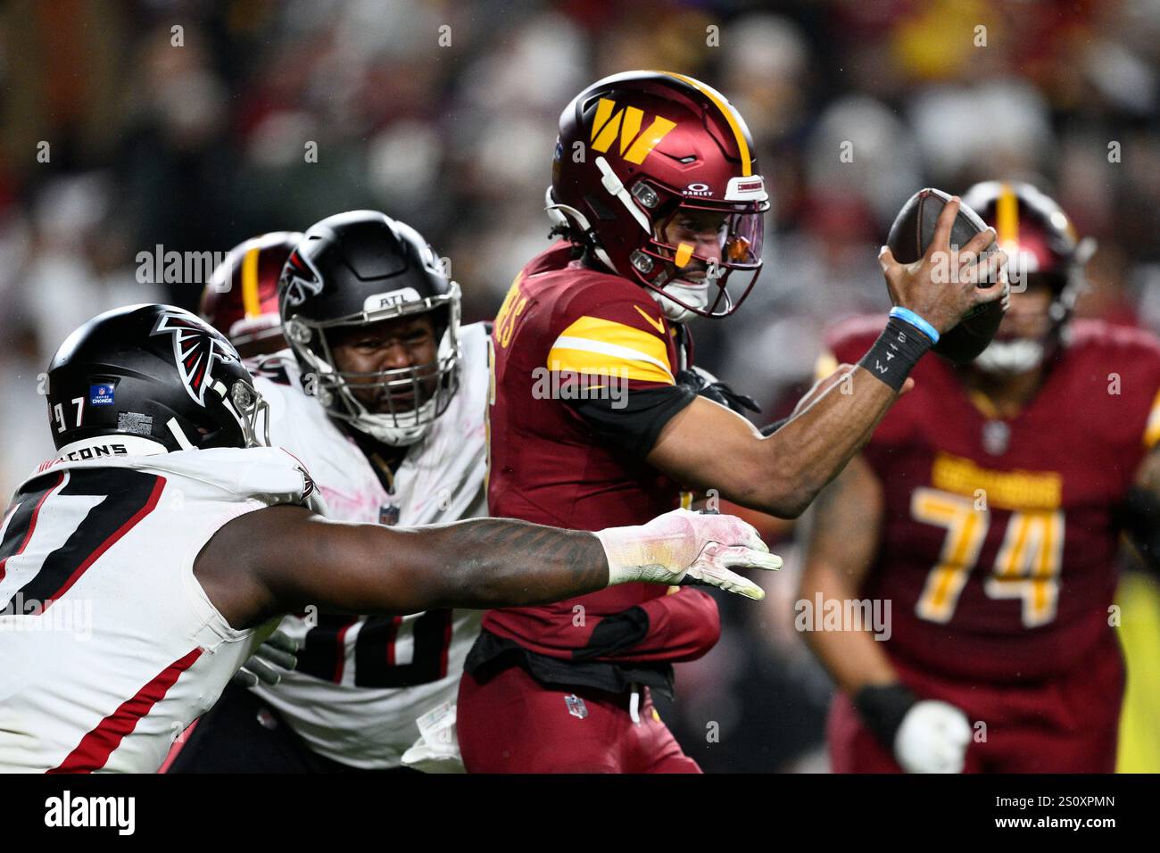 Washington Commanders quarterback Jayden Daniels (5) scrambles from ...