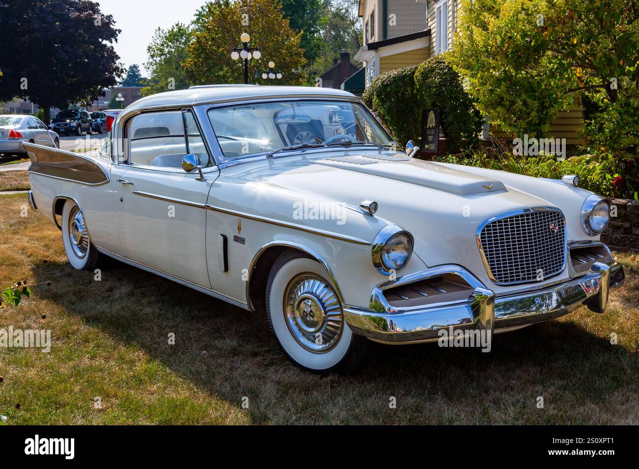 A white and gold 1957 Studebaker Golden Hawk coupe parked in the grass ...