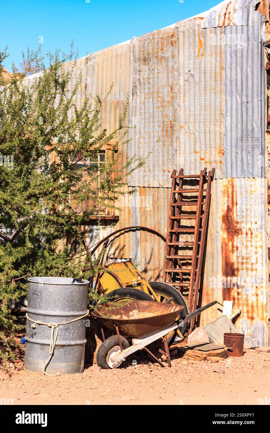 A rusty ladder is leaning against a building. The ladder is old and ...