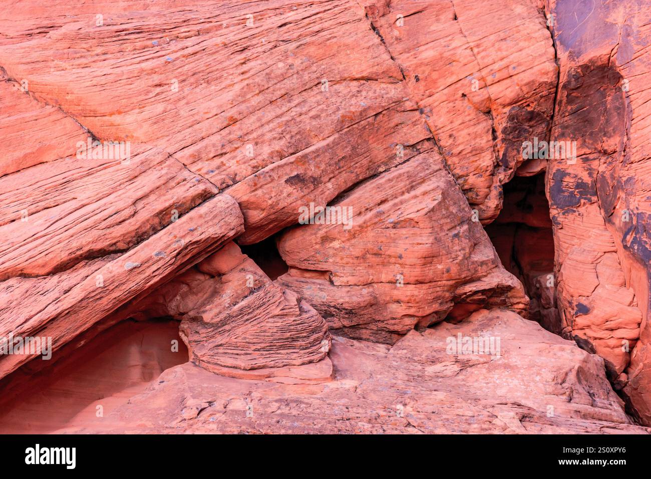 A rock with a hole in it. The rock is red Stock Photo - Alamy