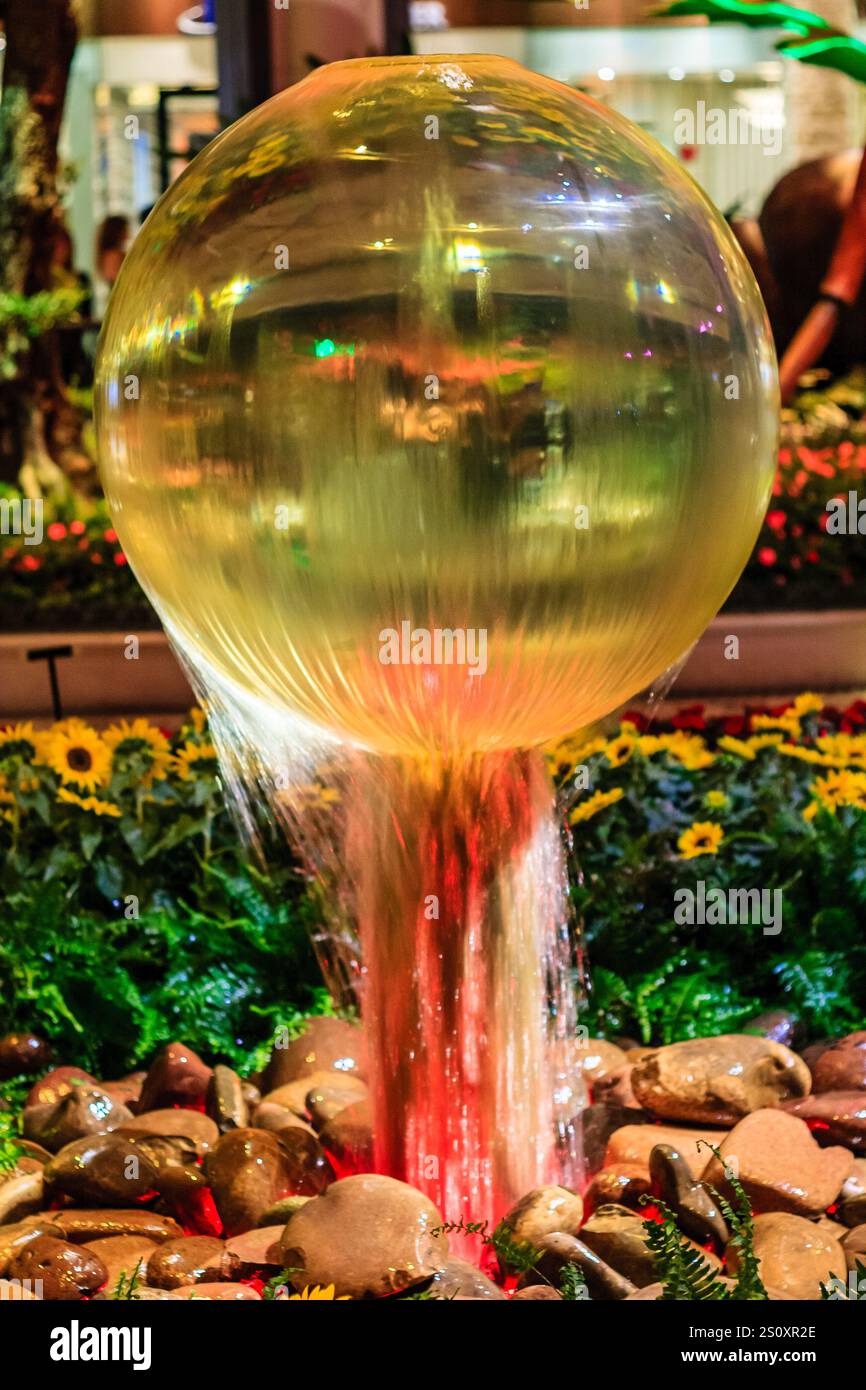 A large yellow ball with a stream of water coming out of it. The water ...