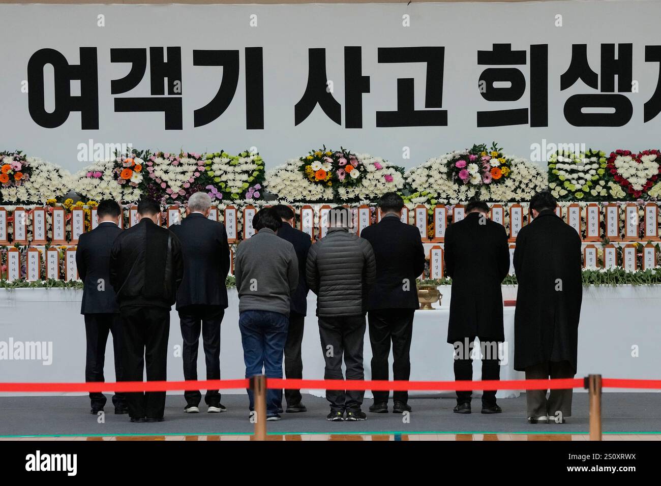 Mourners pray for the victims of a plane fire at a memorial altar at ...
