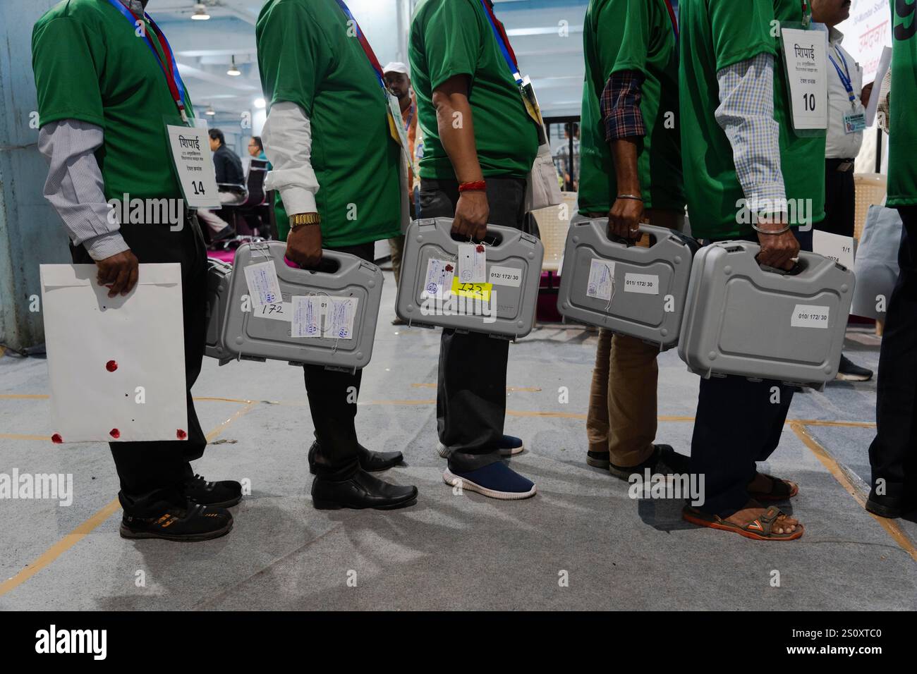 Election officials carry sealed electronic voting machines at a ...