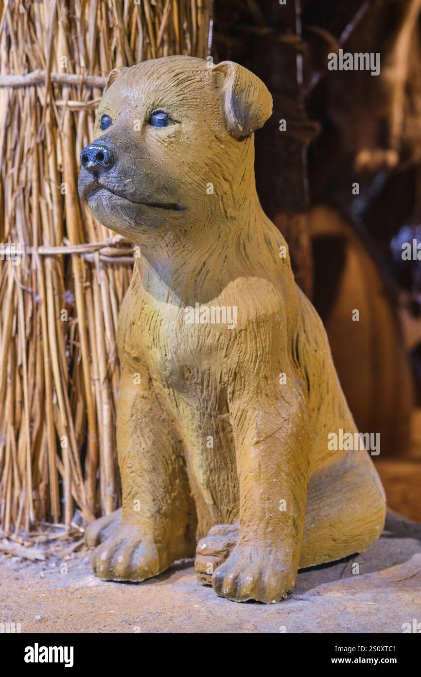 A cute guard dog in front of its village home. At a typical thatch home ...