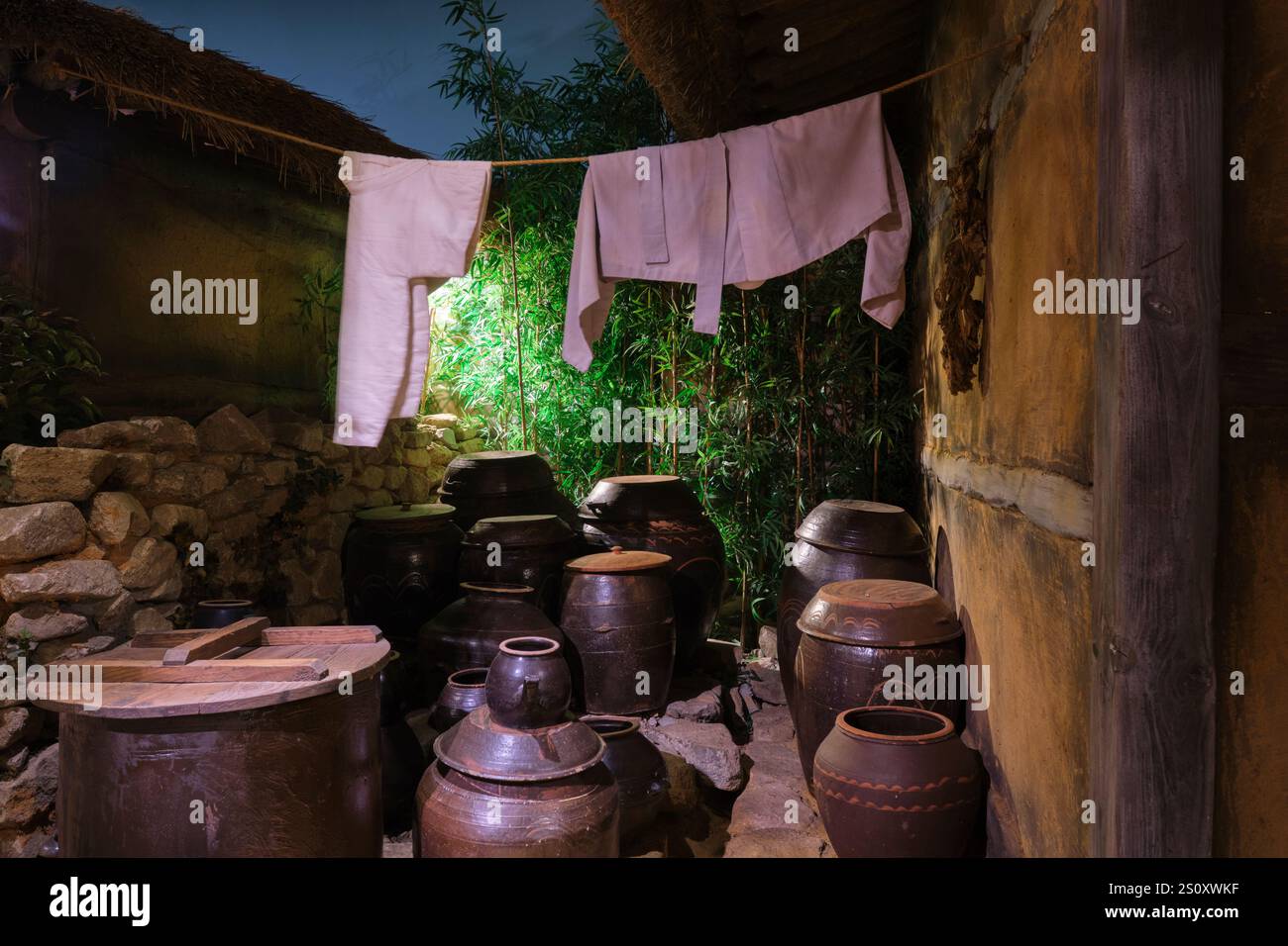 A night view of a village alley with large, clay vases, vessels, maybe ...