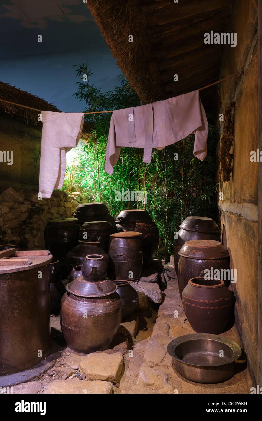 A night view of a village alley with large, clay vases, vessels, maybe ...
