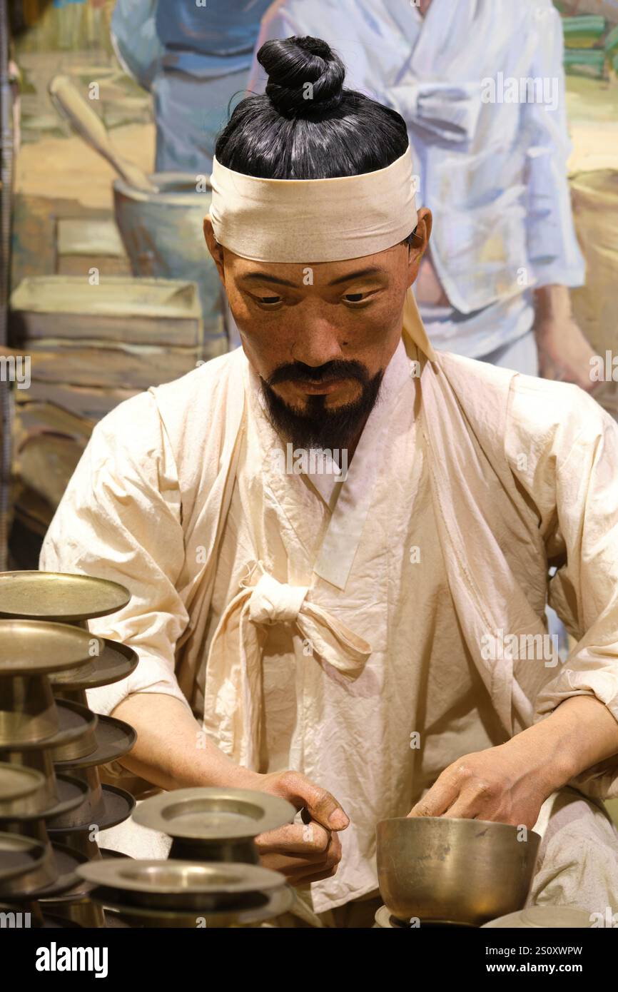A worker shaping, making, beating metal bowls into shape to sell at his ...