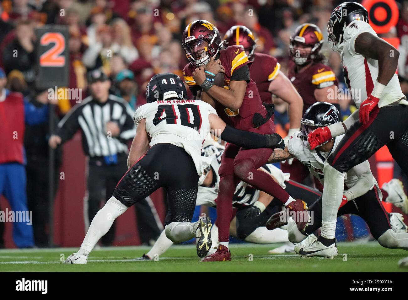 Washington Commanders quarterback Jayden Daniels carries abasing ...
