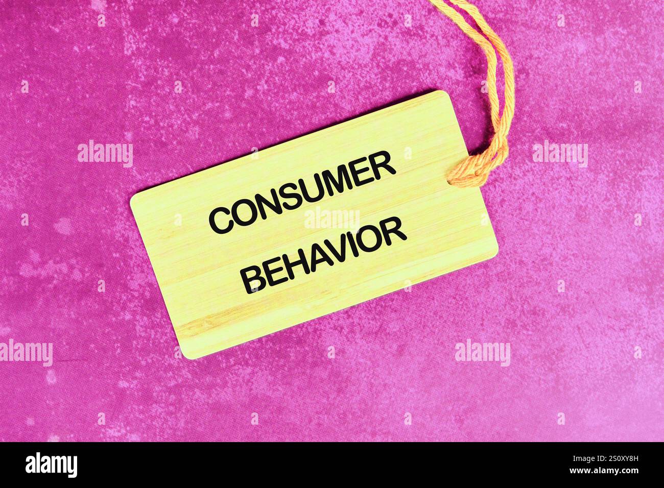 A wooden tag labeled Consumer Behavior displays important marketing ...