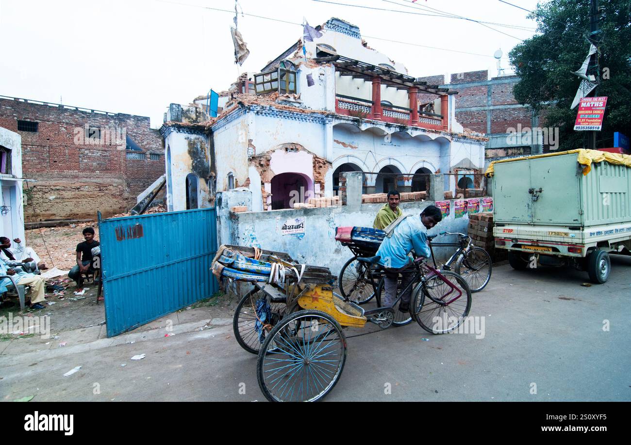 A bicycle rickshaw parked outside an old crumbling building in Lucknow ...