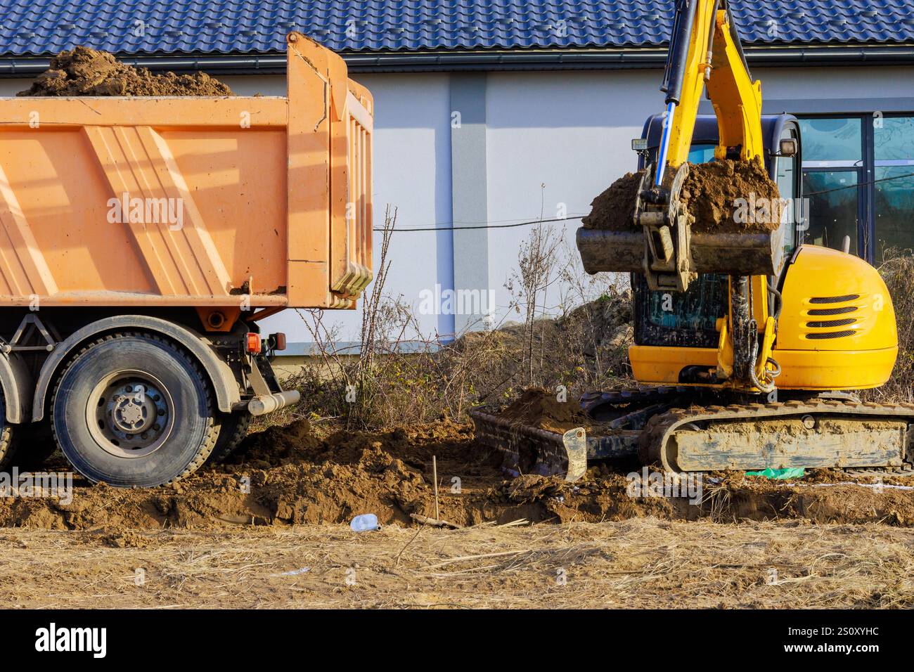 Excavator equipment is moving dirt to prepare ground for landscaping ...