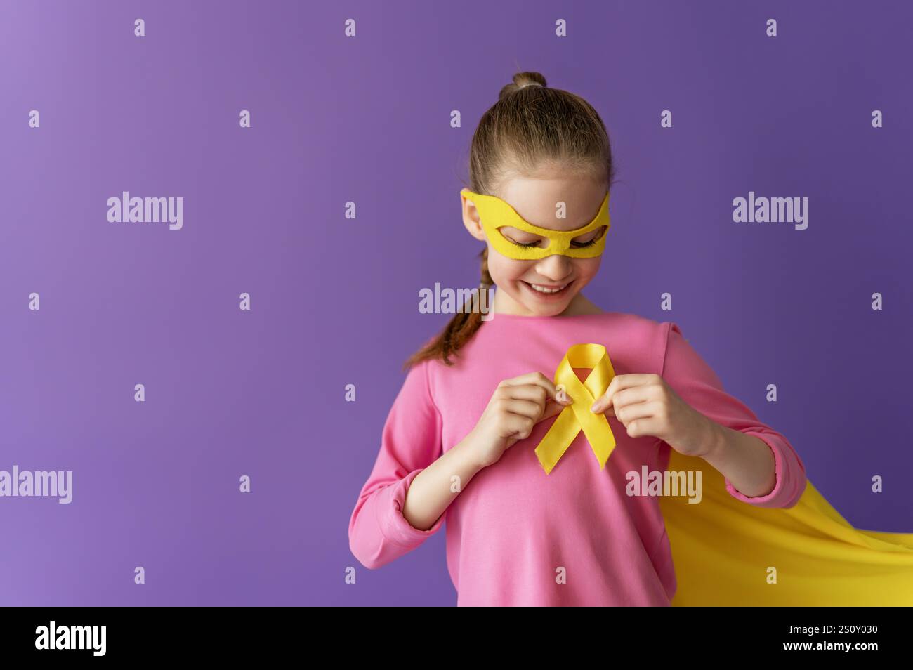 World Childhood cancer Day. Girl in superhero costume with golden ...