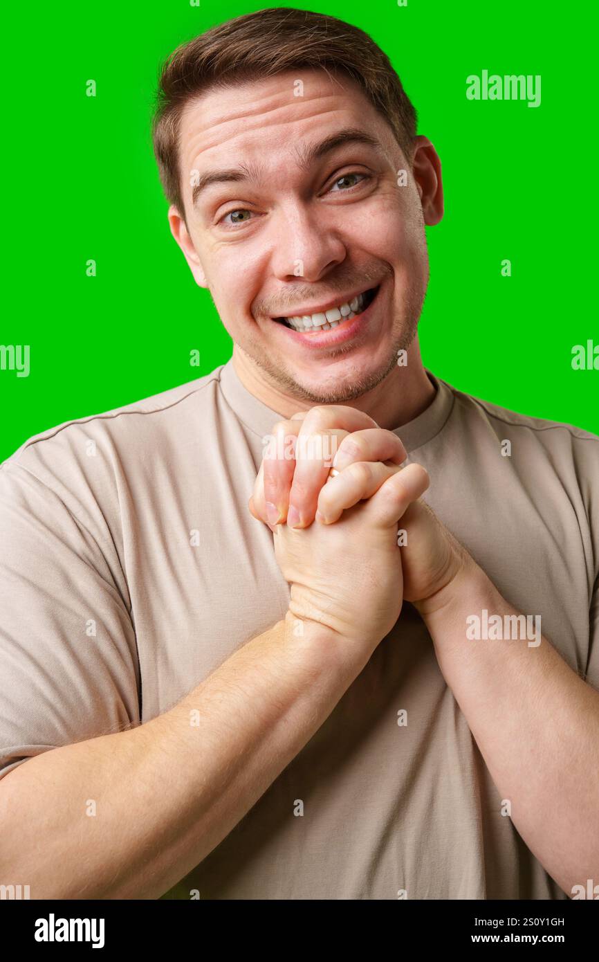 A cheerful man with a friendly smile poses against a bright green ...
