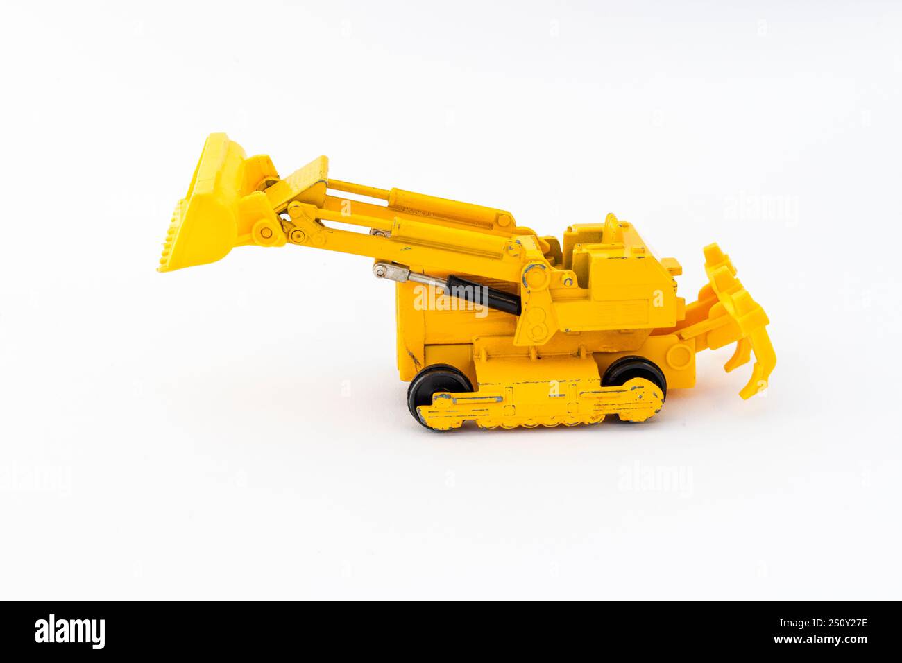 Vintage yellow miniature earth mover model on white isolated background ...
