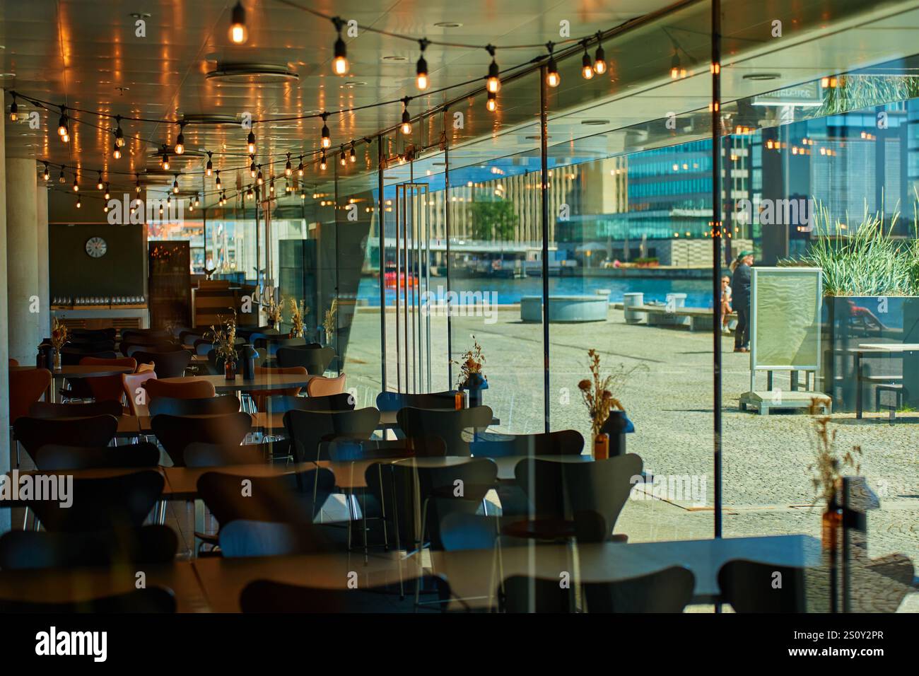 Stylish restaurant interior with large windows. Empty tables in modern ...