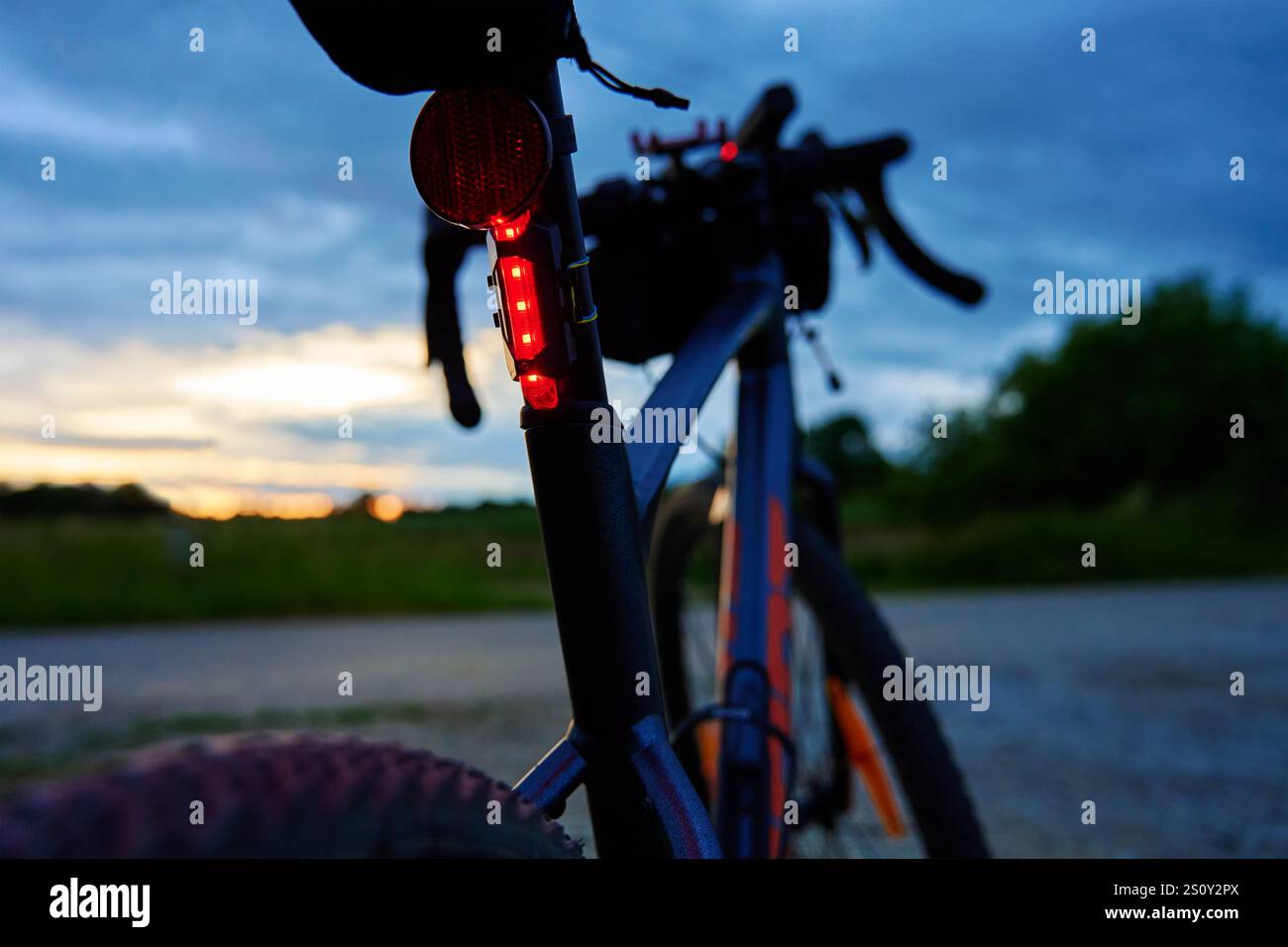 Glowing bicycle tail light in twilight. Red stop light for cyclist ...