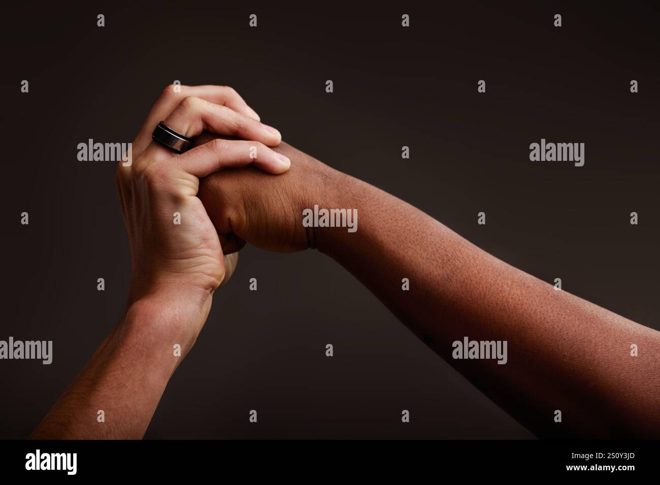 Close-up of two young men's hands clasped together, symbolizing ...