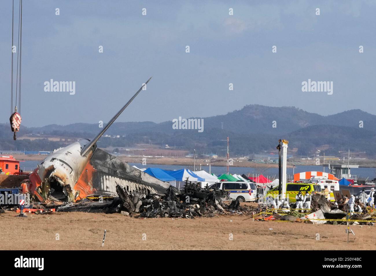 Rescue team members work at the site of a plane fire at Muan ...
