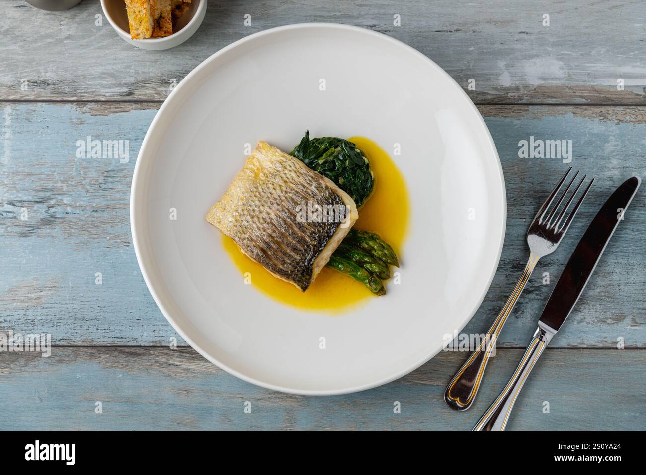 Grilled sea bass fillet served with garnishes in a fine dining ...